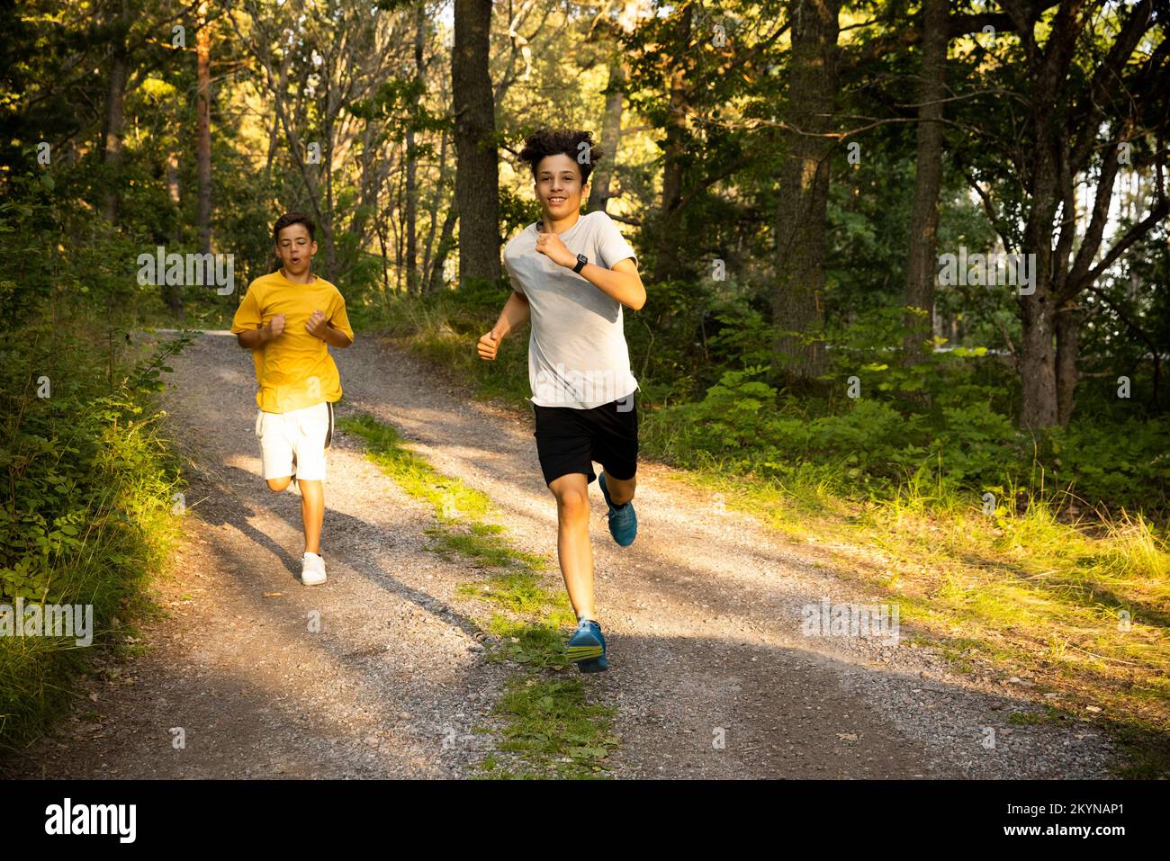 Excited boys running together on dirt road in forest during vacation Stock Photo - Alamy