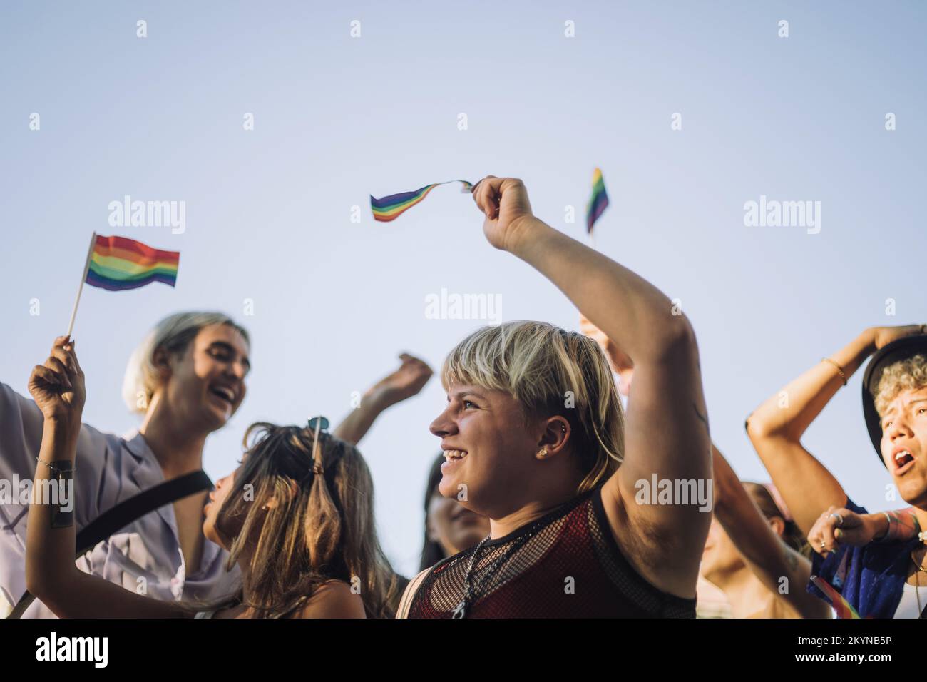 Happy non-binary person with friends enjoying in LGBTQIA rights parade ...