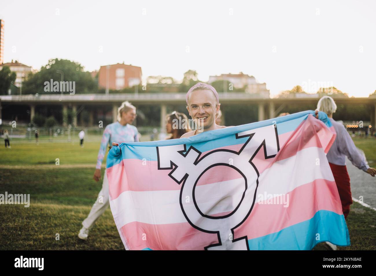 Portrait of happy non-binary person standing with transgender symbol on ...