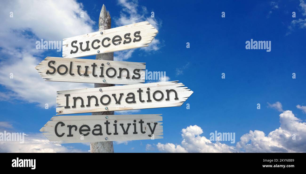 Success, solutions, innovation, creativity - wooden signpost with four ...