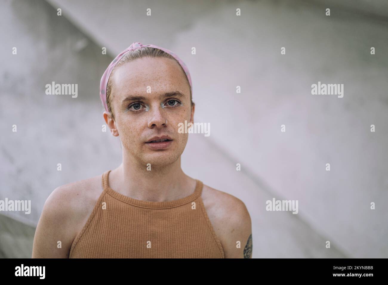 Portrait of non-binary person against wall Stock Photo - Alamy