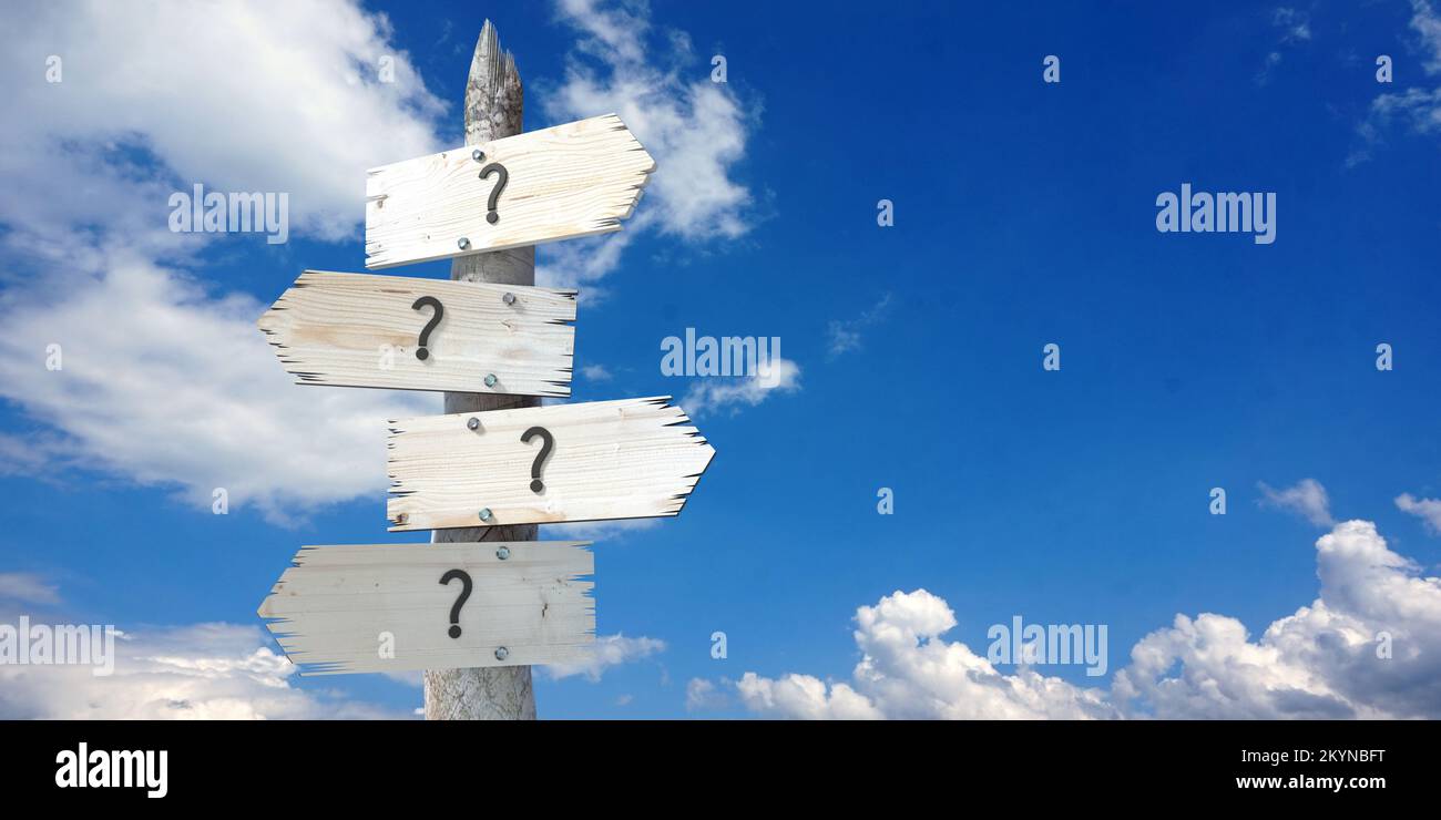 Question marks - wooden signpost with four arrows Stock Photo - Alamy