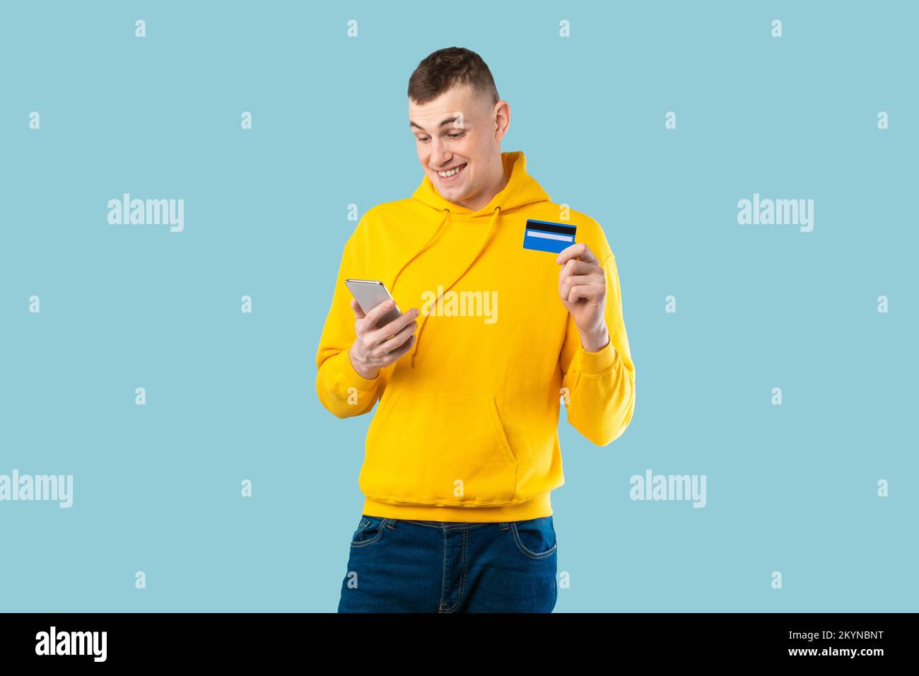 Happy european guy shopping online via smartphone and credit card ...