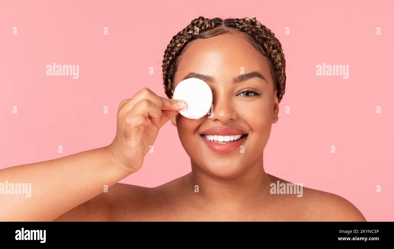 Black body positive woman with perfect skin removing makeup with cotton ...