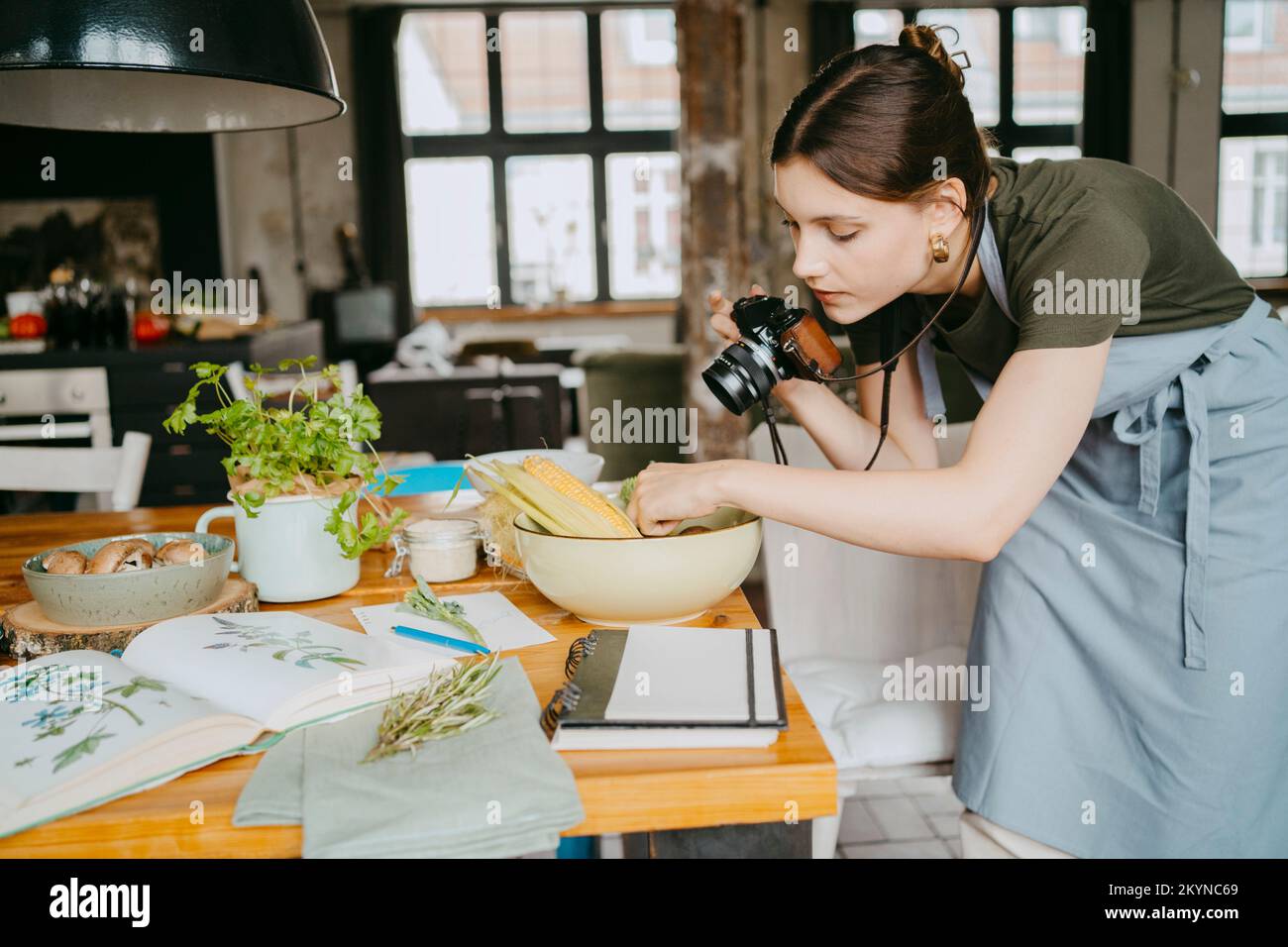 Female food stylist with digital camera setting up vegetable bowl on ...