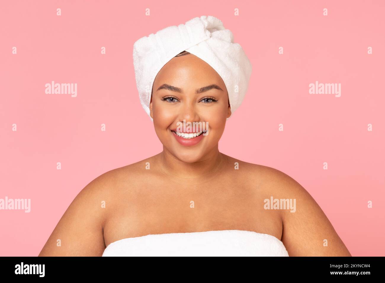 Beauty portrait of body positive black woman standing wrapped in towel ...