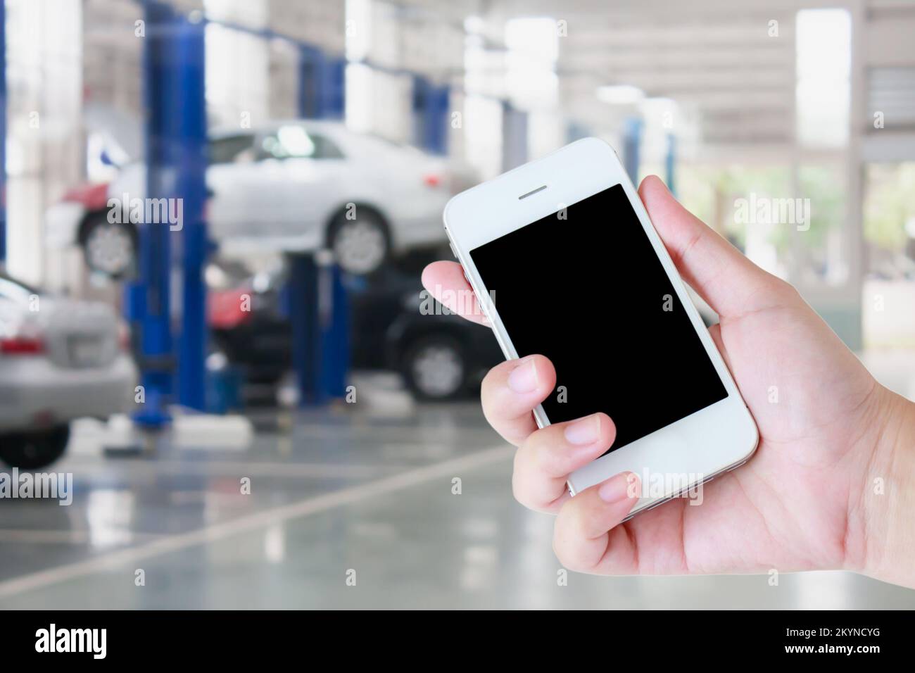 hand hold smartphone with auto tire repair services blurred background ...