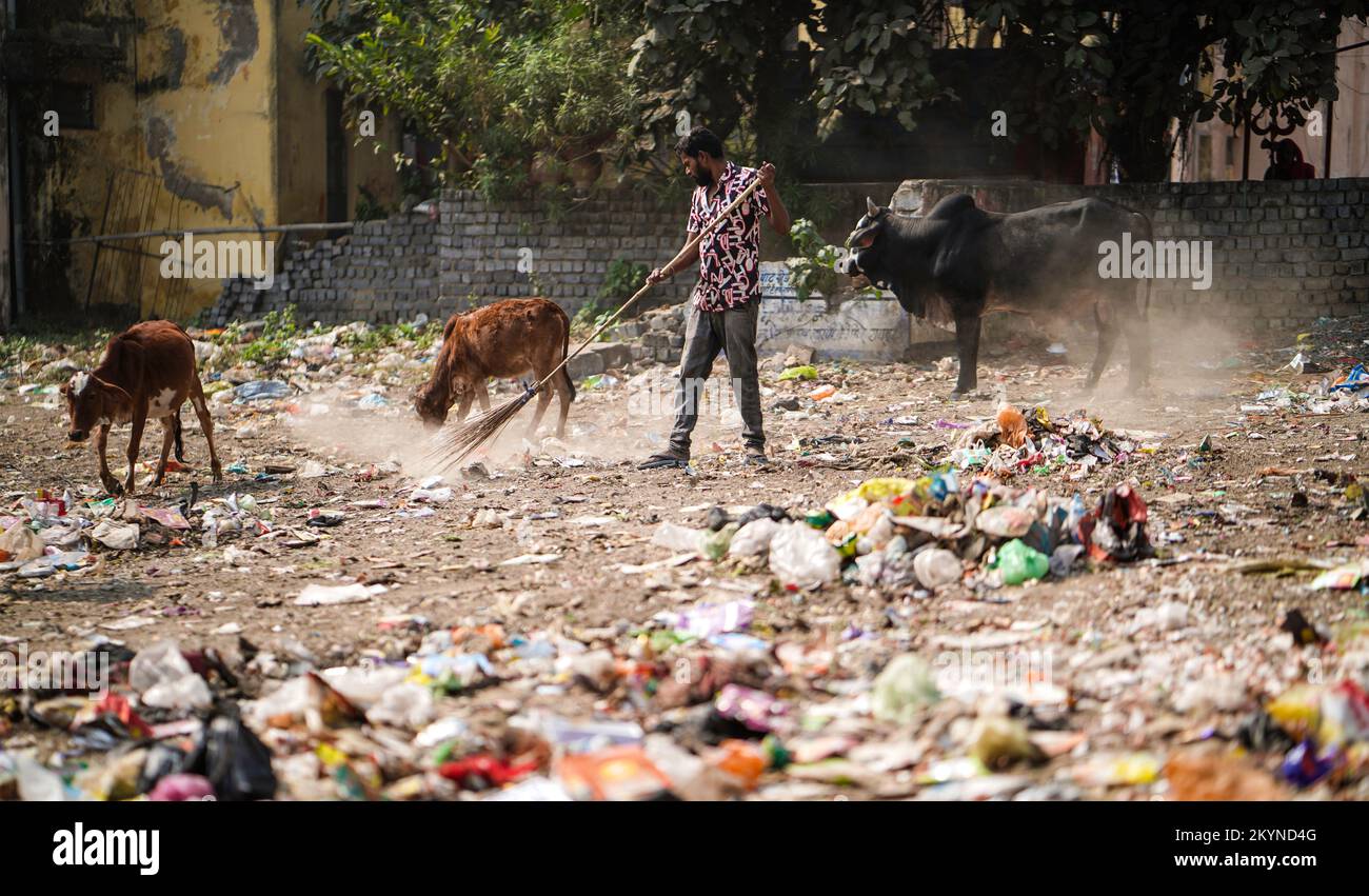 Man sweeping the trash with broom and polyhthene big garbage area, Man ...