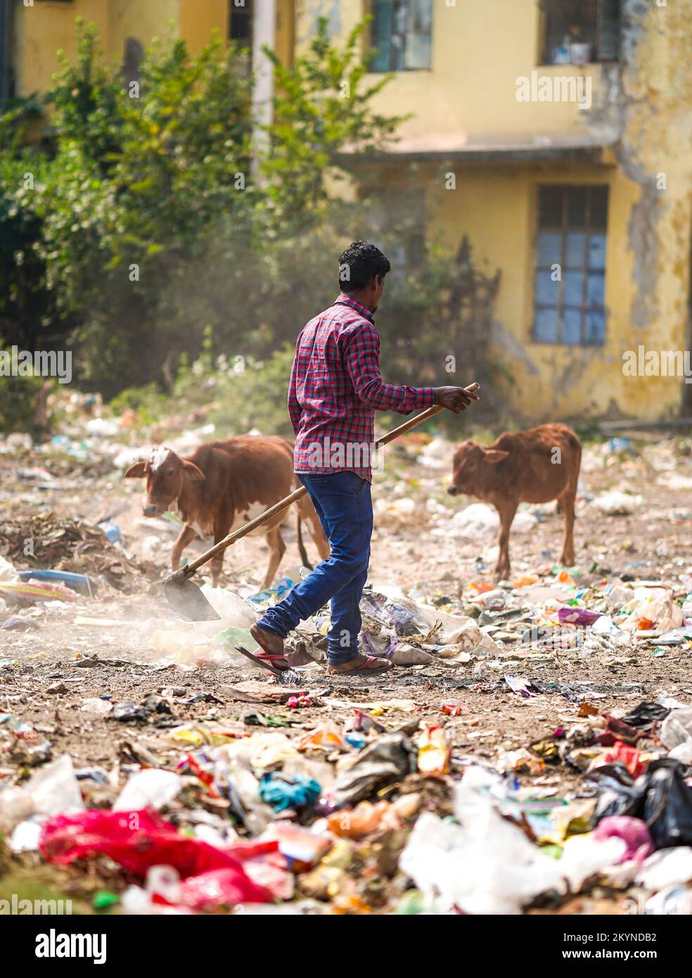 Man sweeping the trash with broom and polyhthene big garbage area, Man ...