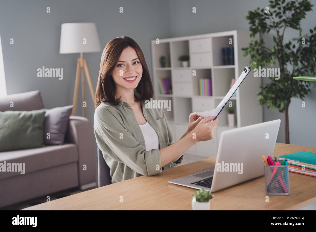 Portrait of pretty friendly attorney girl sit chair hold read documents ...