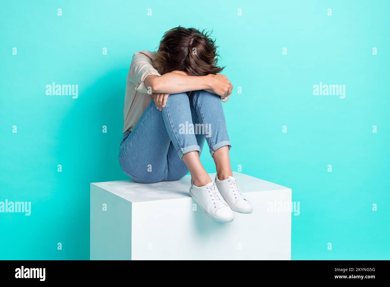 Full length photo of moody girlfriend sitting white cube hiding face ...