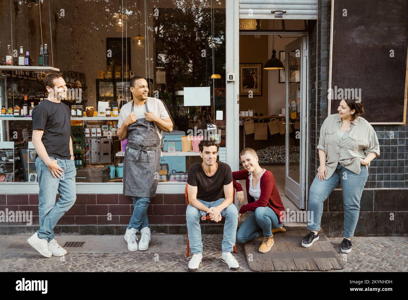 Multiracial shop owners talking to each other outside deli Stock Photo ...