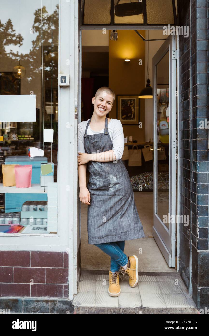 Portrait of happy female owner leaning on store doorway Stock Photo - Alamy