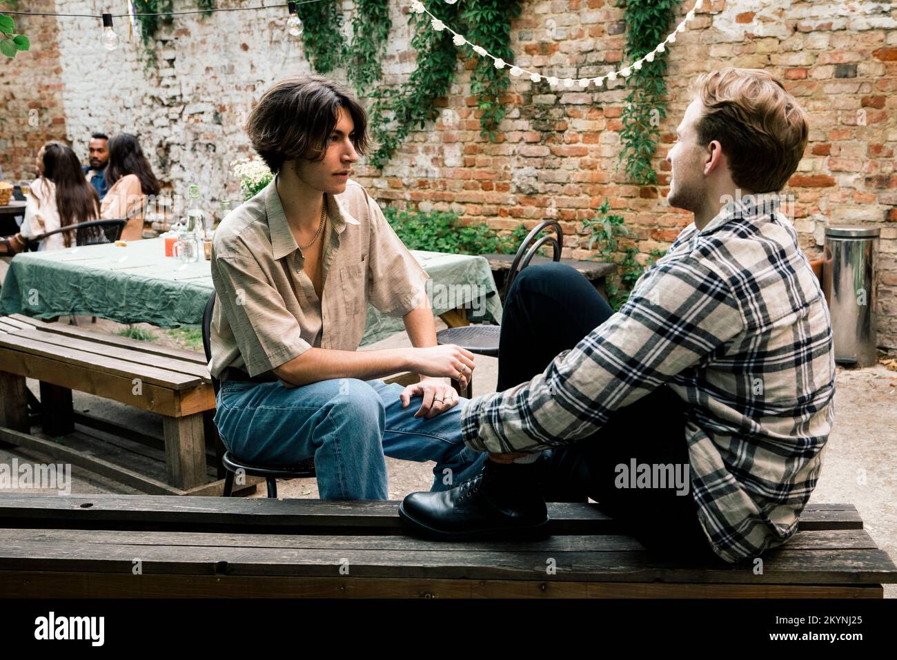 Two friends sitting back back hi-res stock photography and images - Alamy