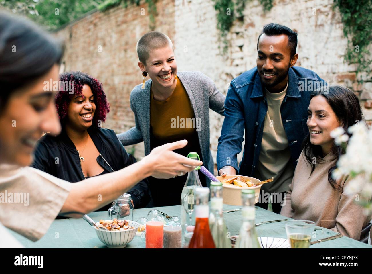Happy friends spending leisure time with each other at garden party in ...