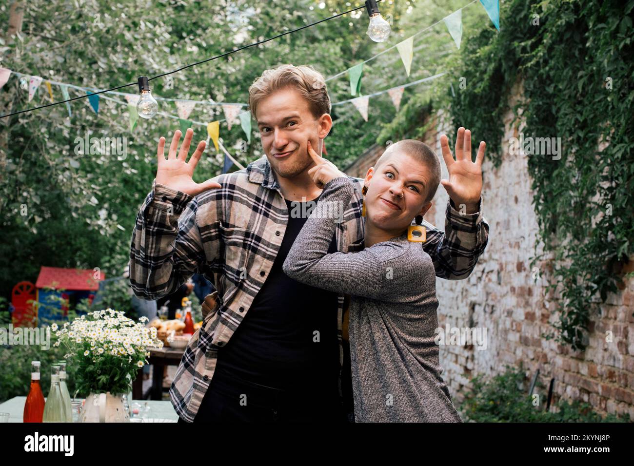 Portrait of playful friends making faces and gesturing at dinner party ...
