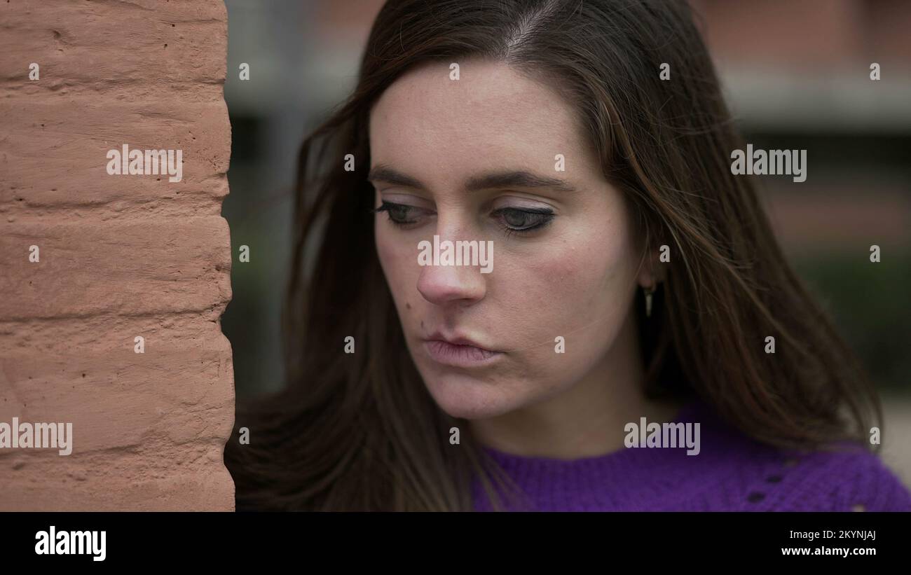 Worried young woman concerned thinking outside biting lip Stock Photo ...