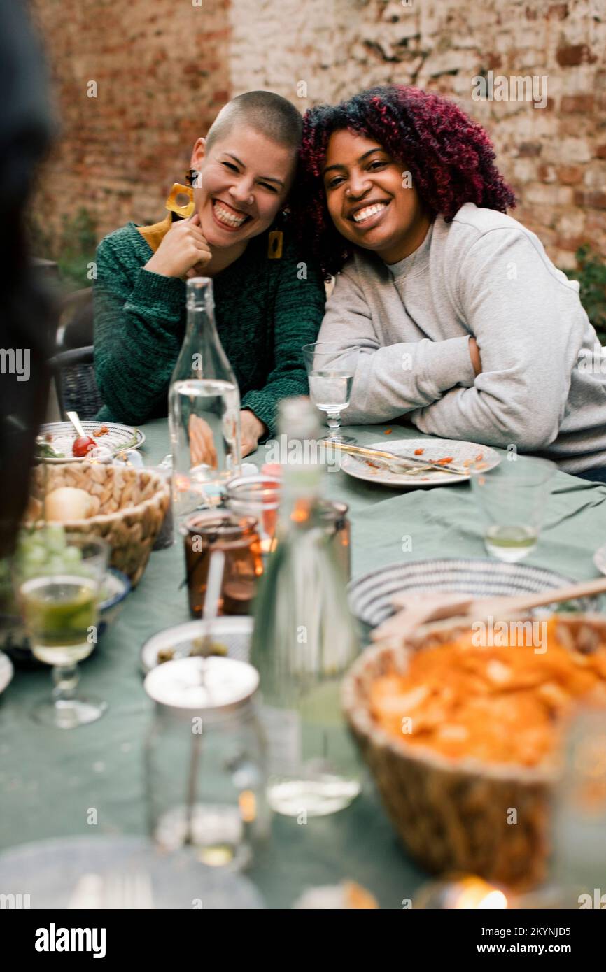 Portrait of multiracial female friends at dining table during dinner ...