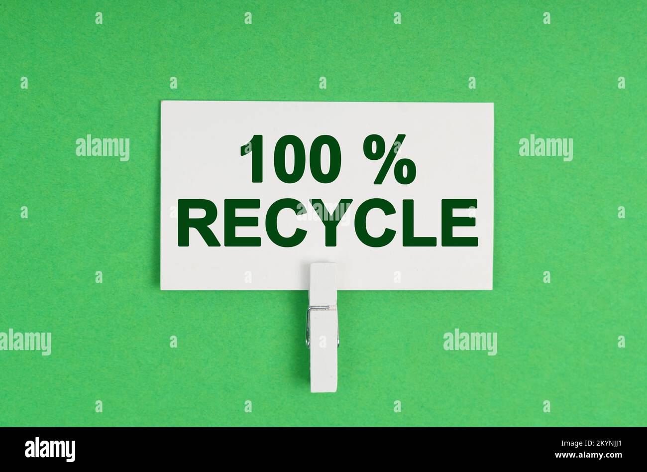 Ecology concept. On a green background, a business card on a clothespin ...