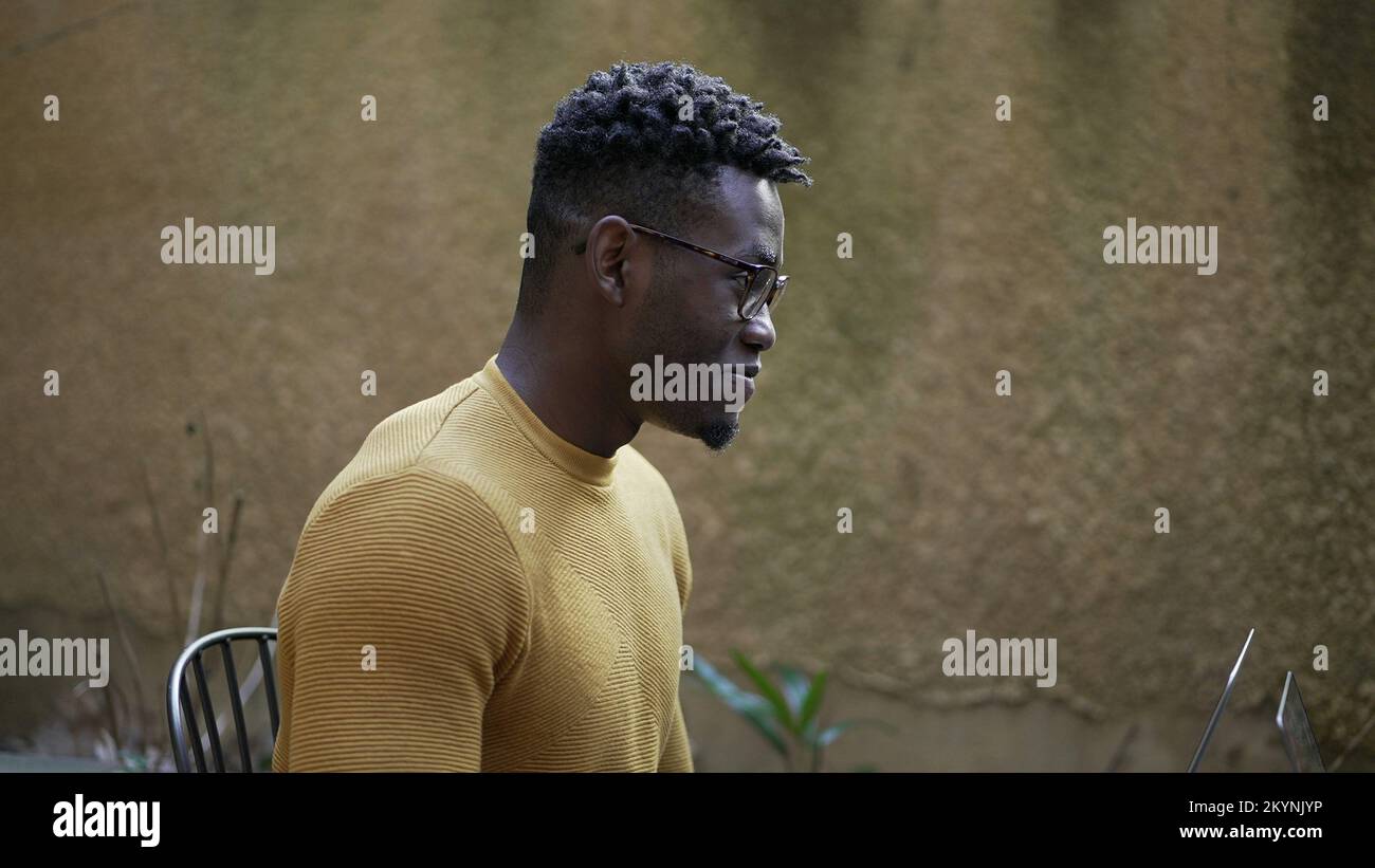 Smart young black African working from home in front of laptop computer ...