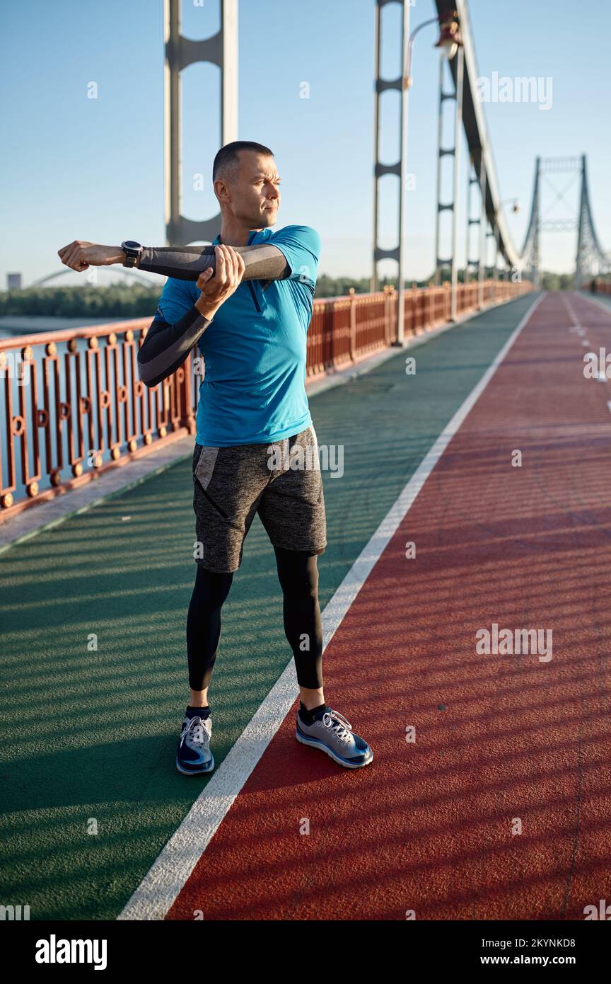 Fitness runner doing warm-up routine before speed running Stock Photo ...