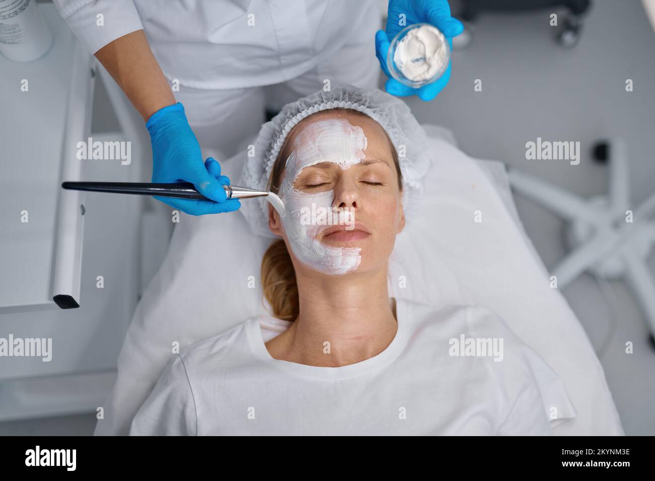 Cosmetologist applying mask on client face in spa salon Stock Photo - Alamy