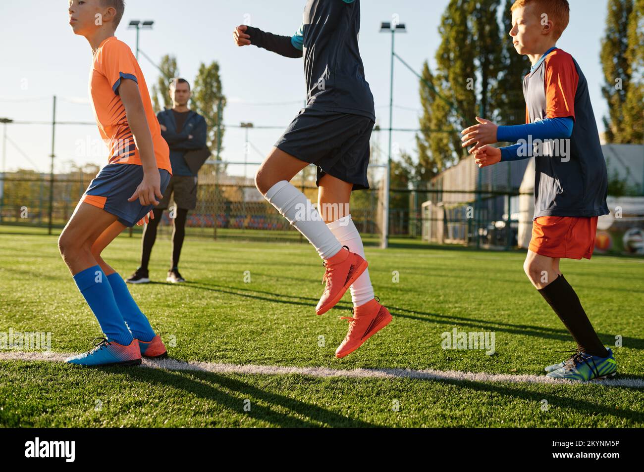 Group of boys running on green football field during training class ...