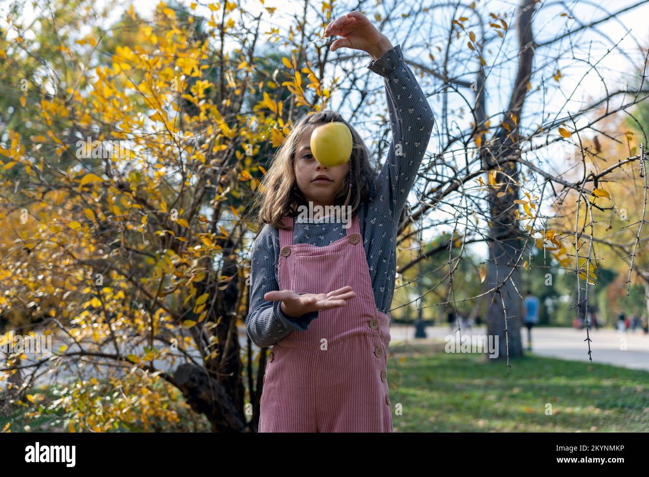 Cute girl in casual clothes dropping fresh apple on hand while standing ...