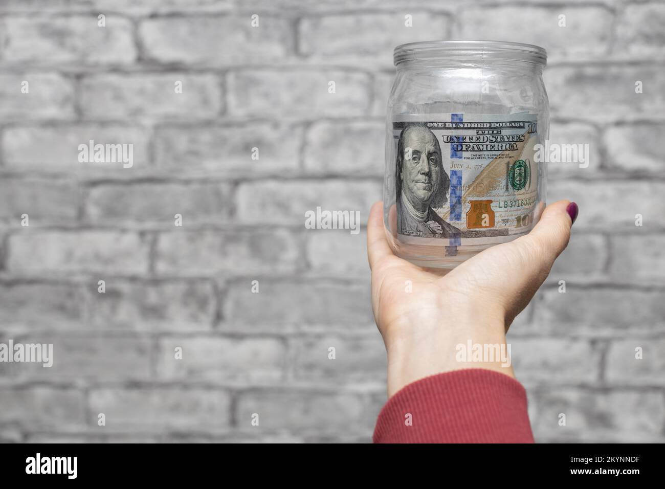 hand holding a glass jar of money Stock Photo - Alamy