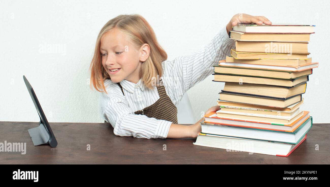 Education concept. Teenage girl pushes books aside, choosing a tablet ...