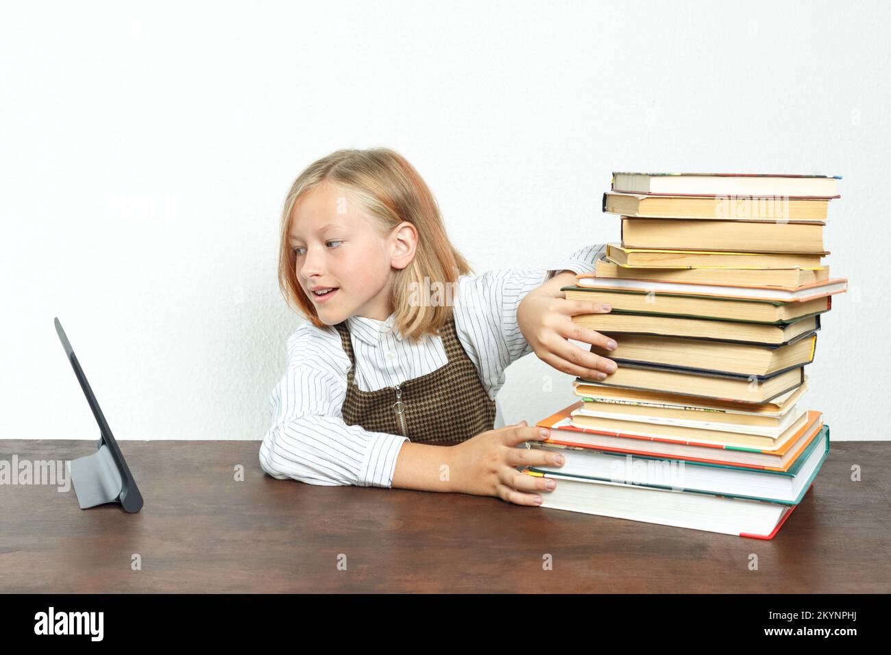Education concept. Teenage girl pushes books aside, choosing a tablet ...