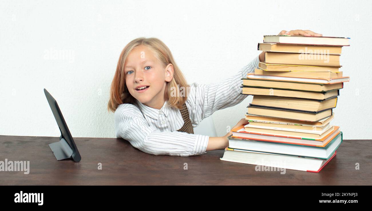 Education concept. Teenage girl pushes books aside, choosing a tablet ...