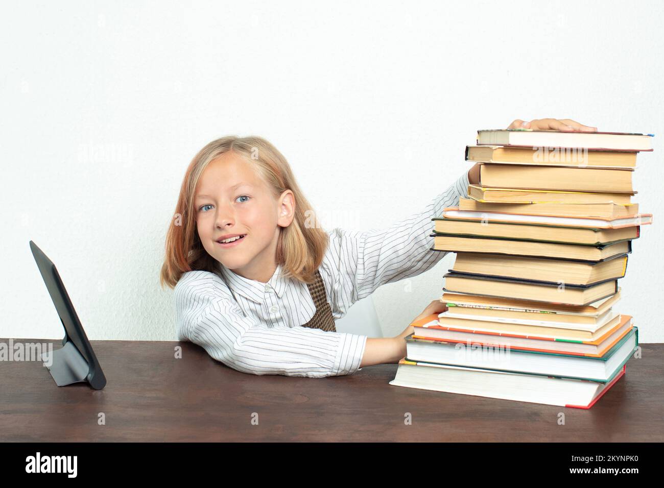 Education concept. Teenage girl pushes books aside, choosing a tablet ...