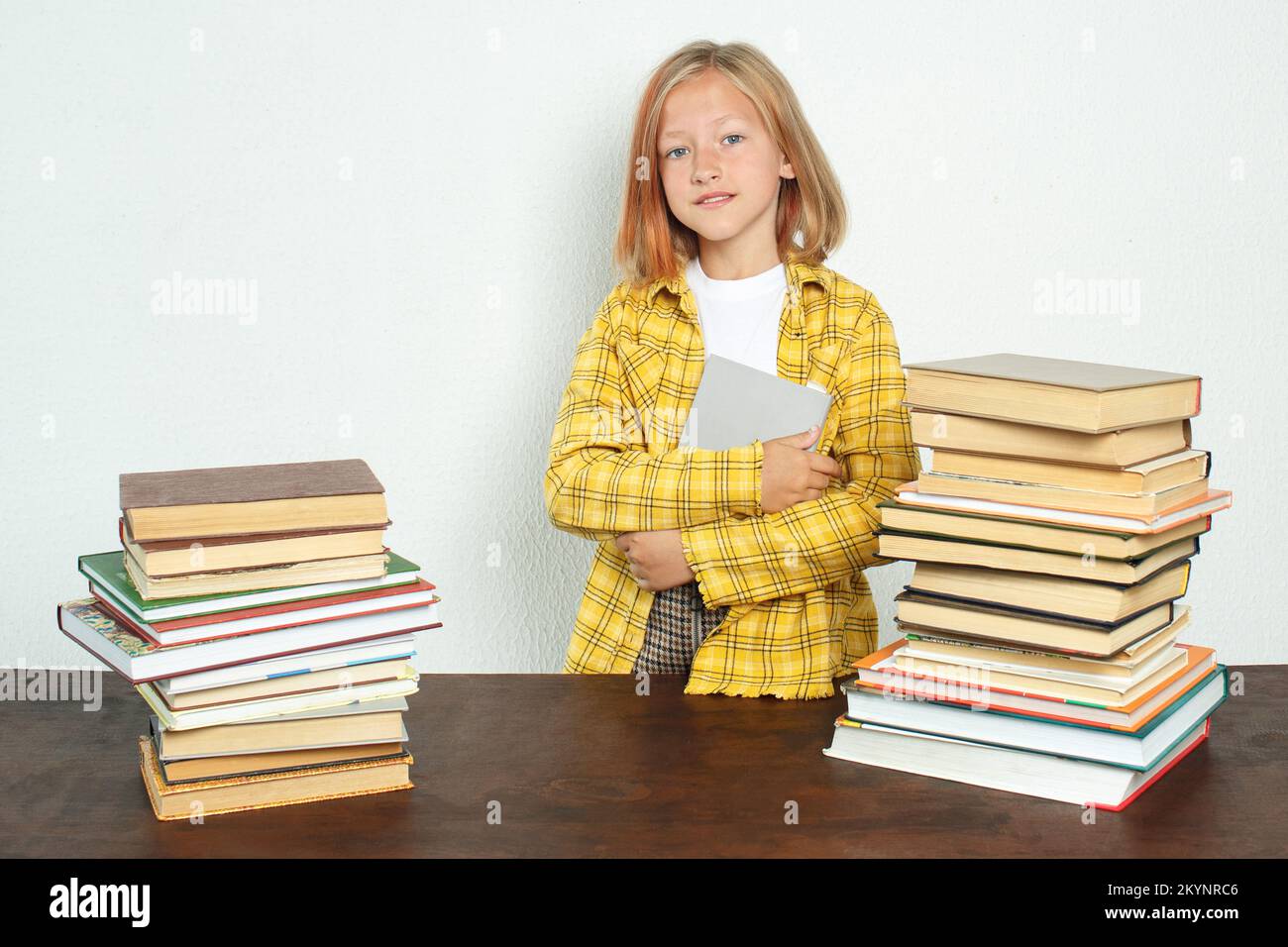 Education concept. A teenage girl stands near a table with books ...