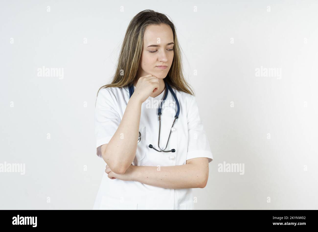 Medicine and health concept. A young woman doctor is thinking, dreaming ...