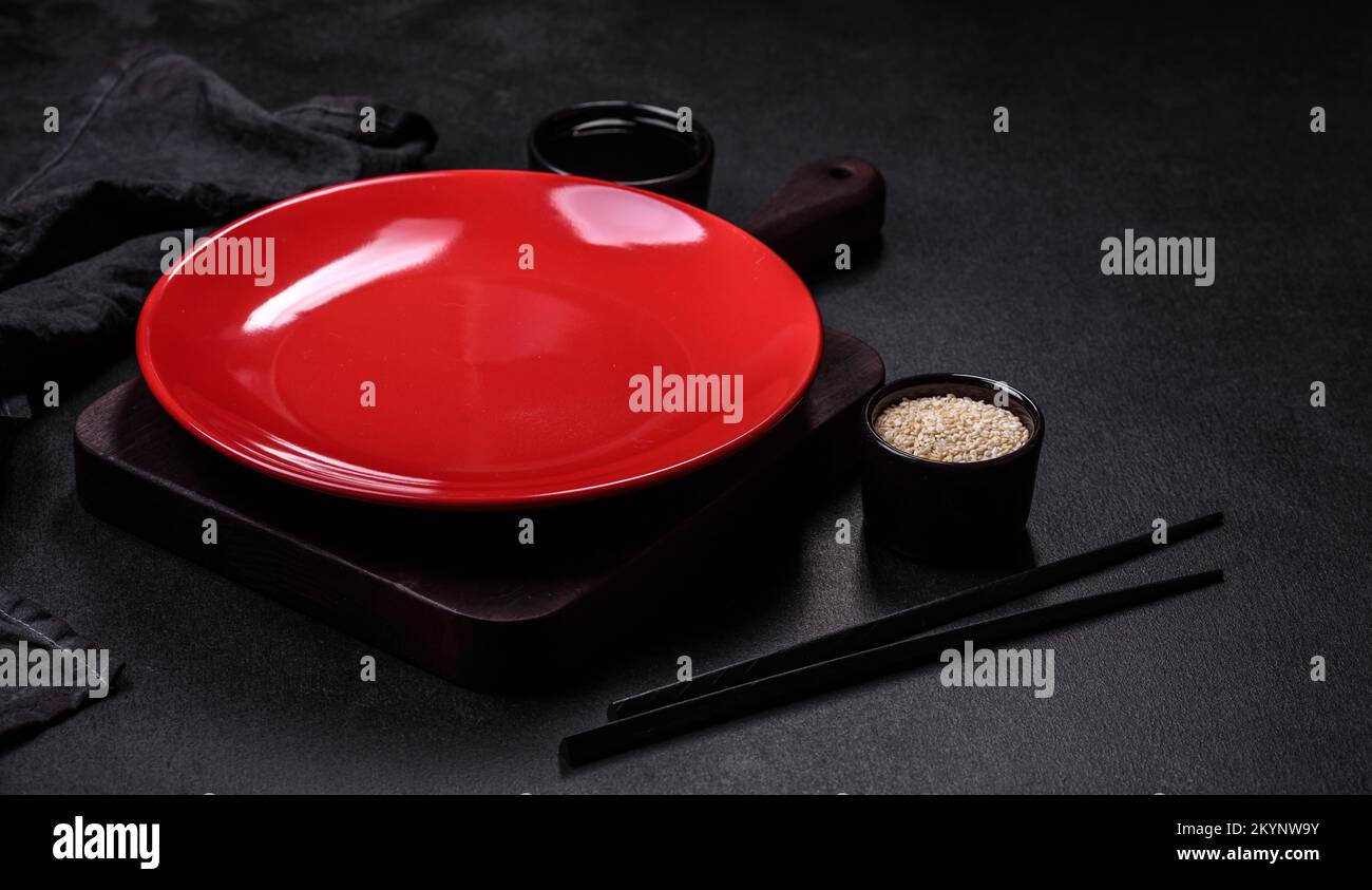 Empty plate with wooden sticks for Asian food on a dark concrete ...