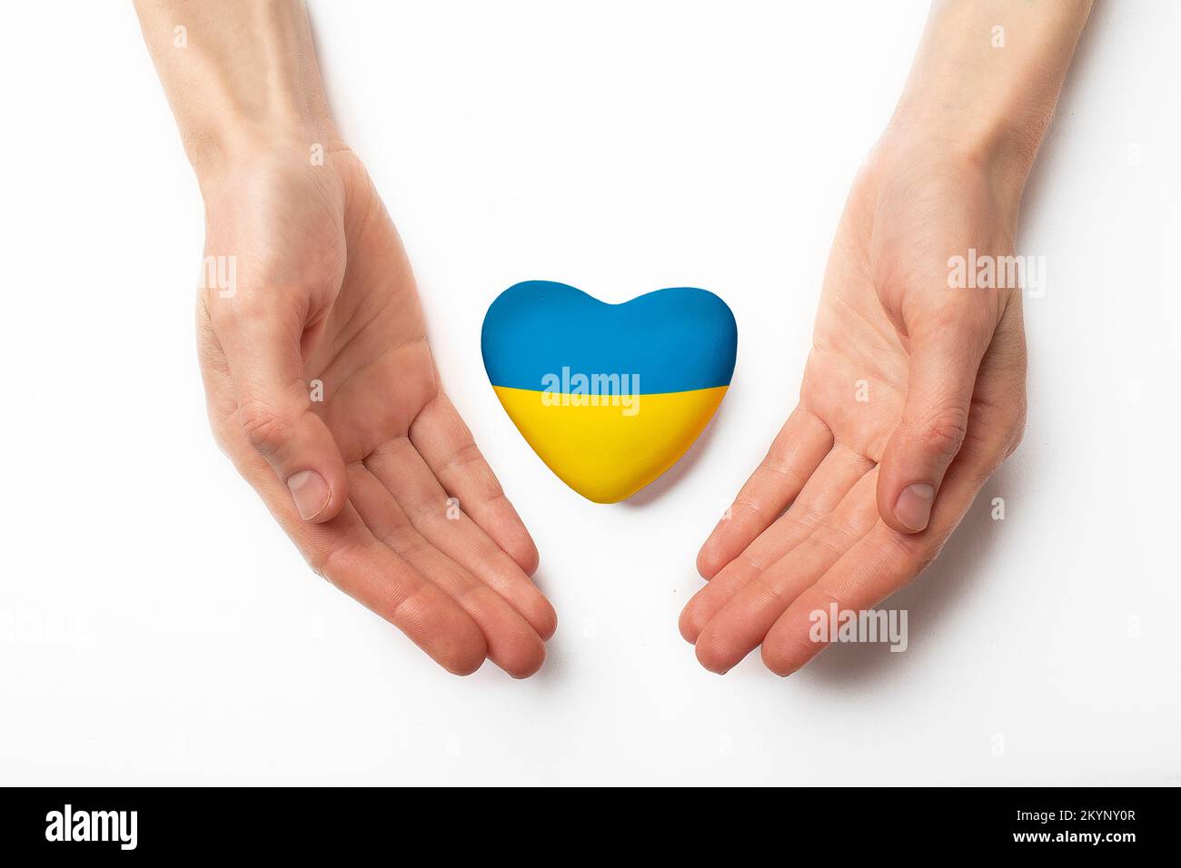 High angle view of child hands holding ukraine flag painted heart ...