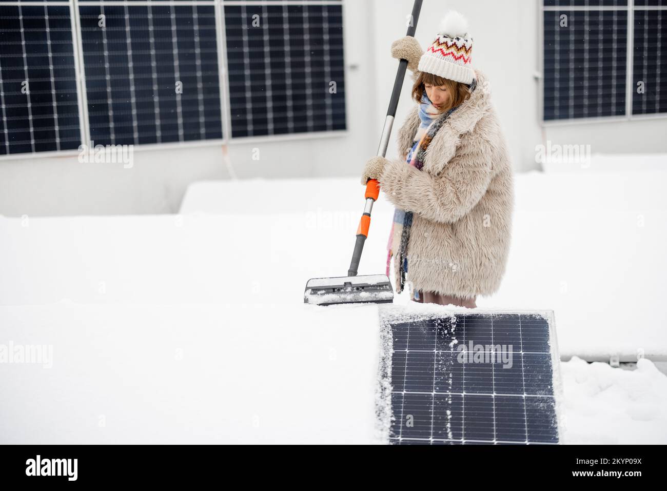 Woman cleans solar panels from snow Stock Photo - Alamy
