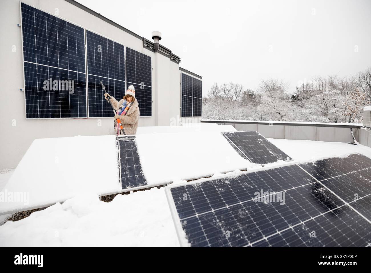 Woman cleans solar panels from snow Stock Photo - Alamy