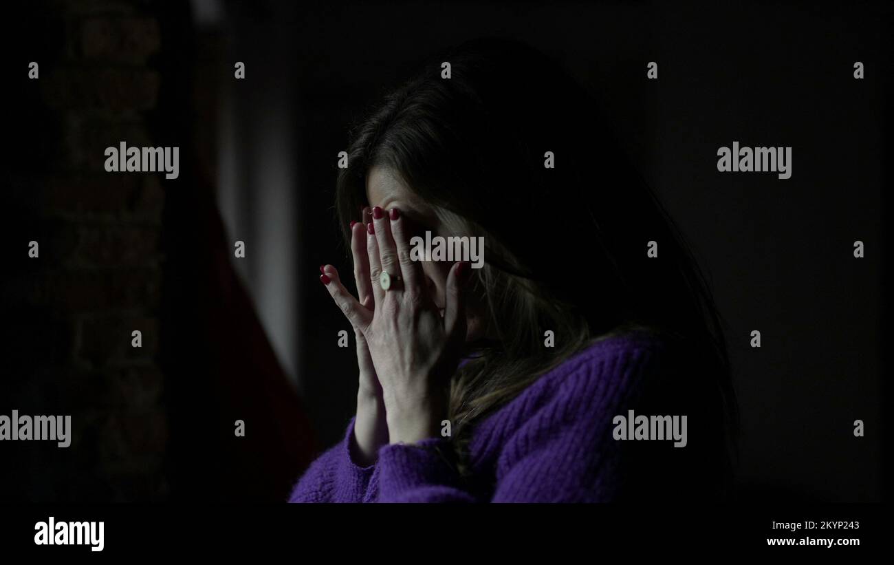 Young woman standing by window having a headache. Anxious concerned ...