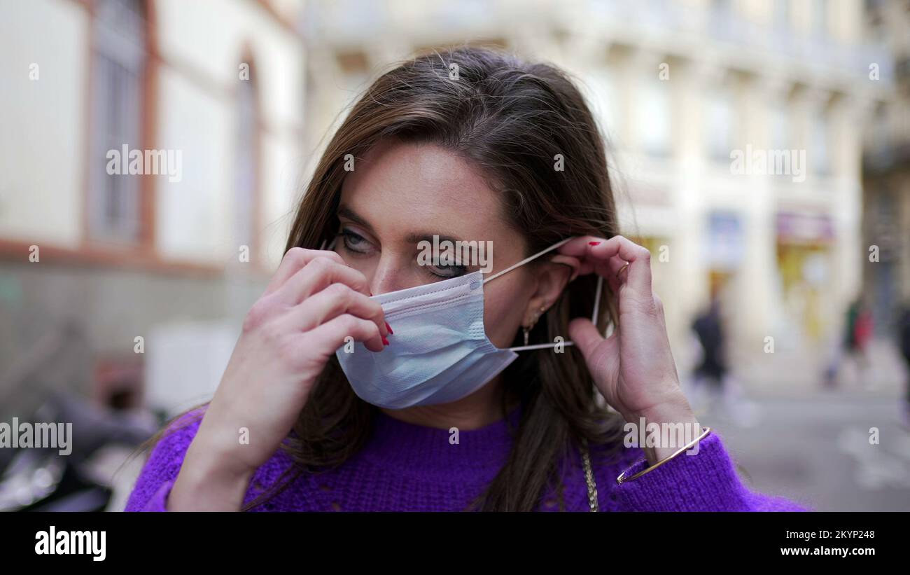 Young woman putting covid-19 face mask. Person wearing surgicak mask ...