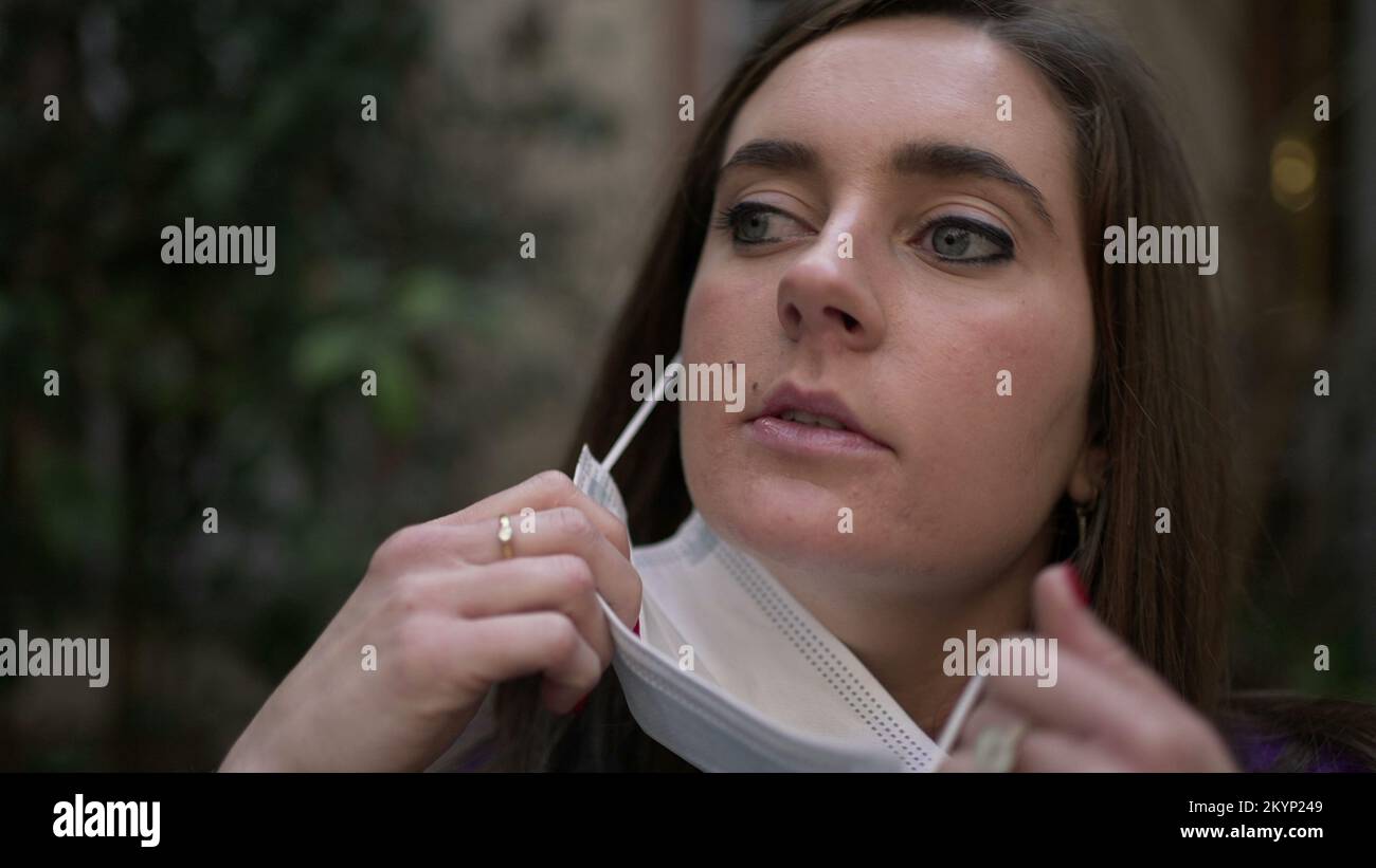 Young woman putting covid-19 face mask. Girl wears surgical mask Stock ...