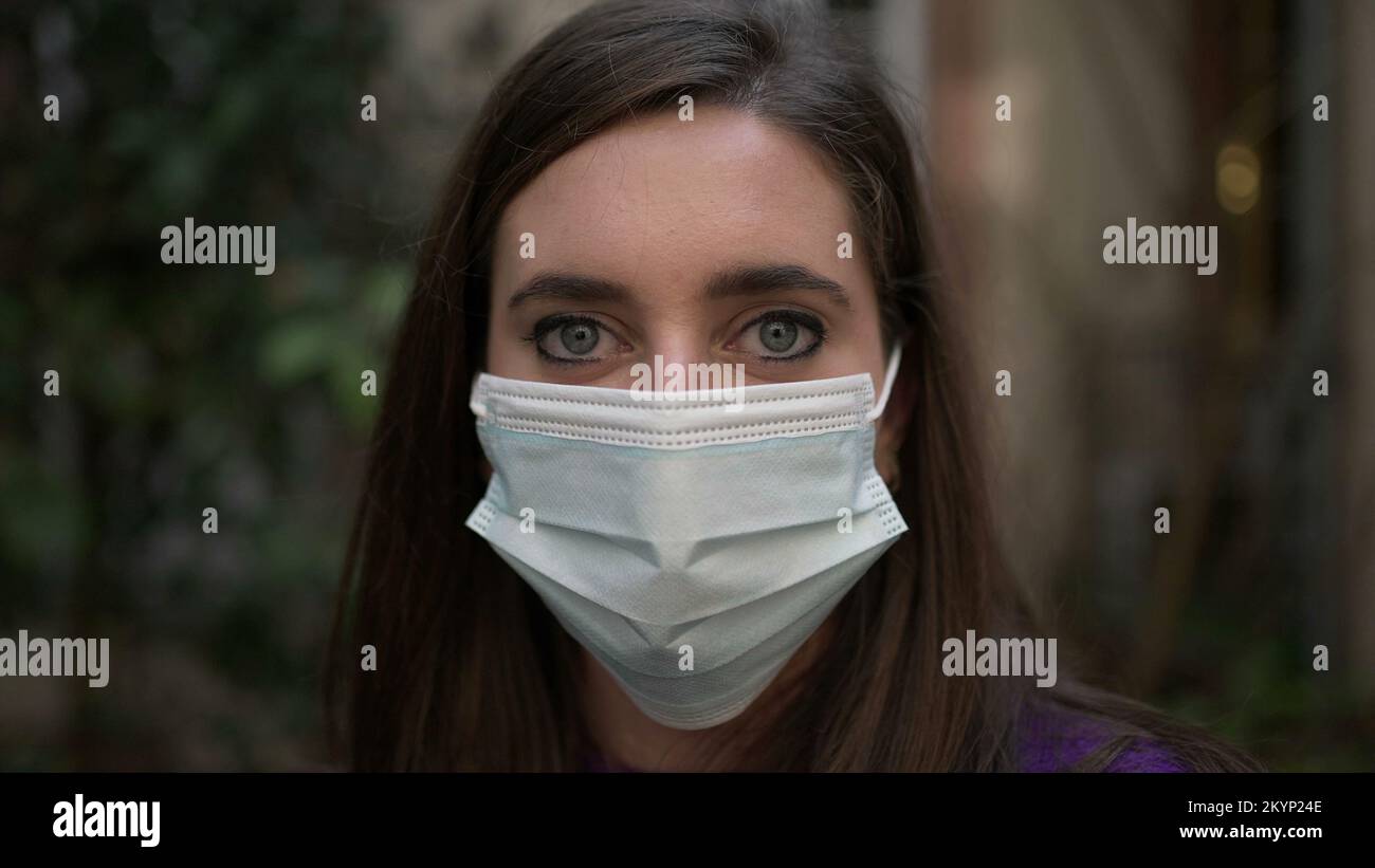 Young woman putting covid-19 face mask. Girl wears surgical mask Stock ...