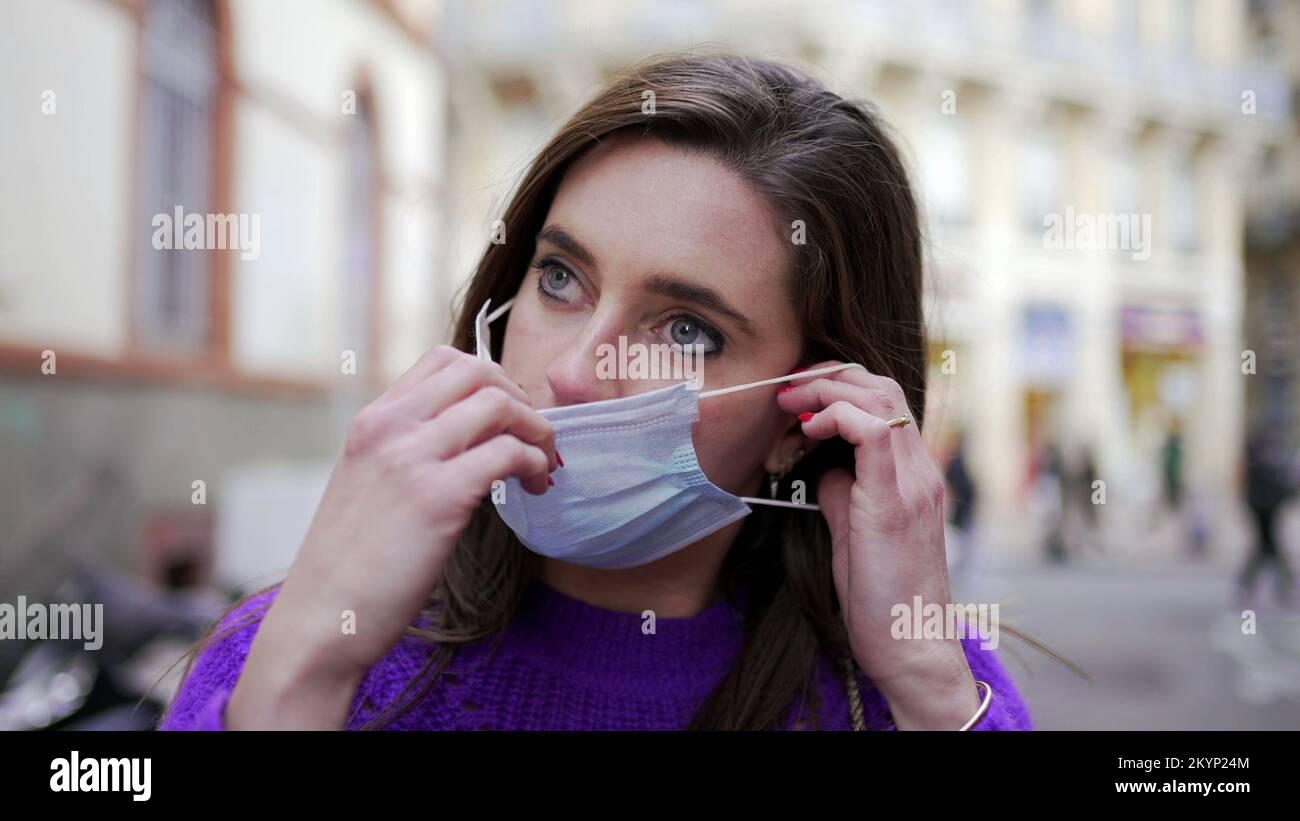 Young woman putting covid-19 face mask. Person wearing surgicak mask ...
