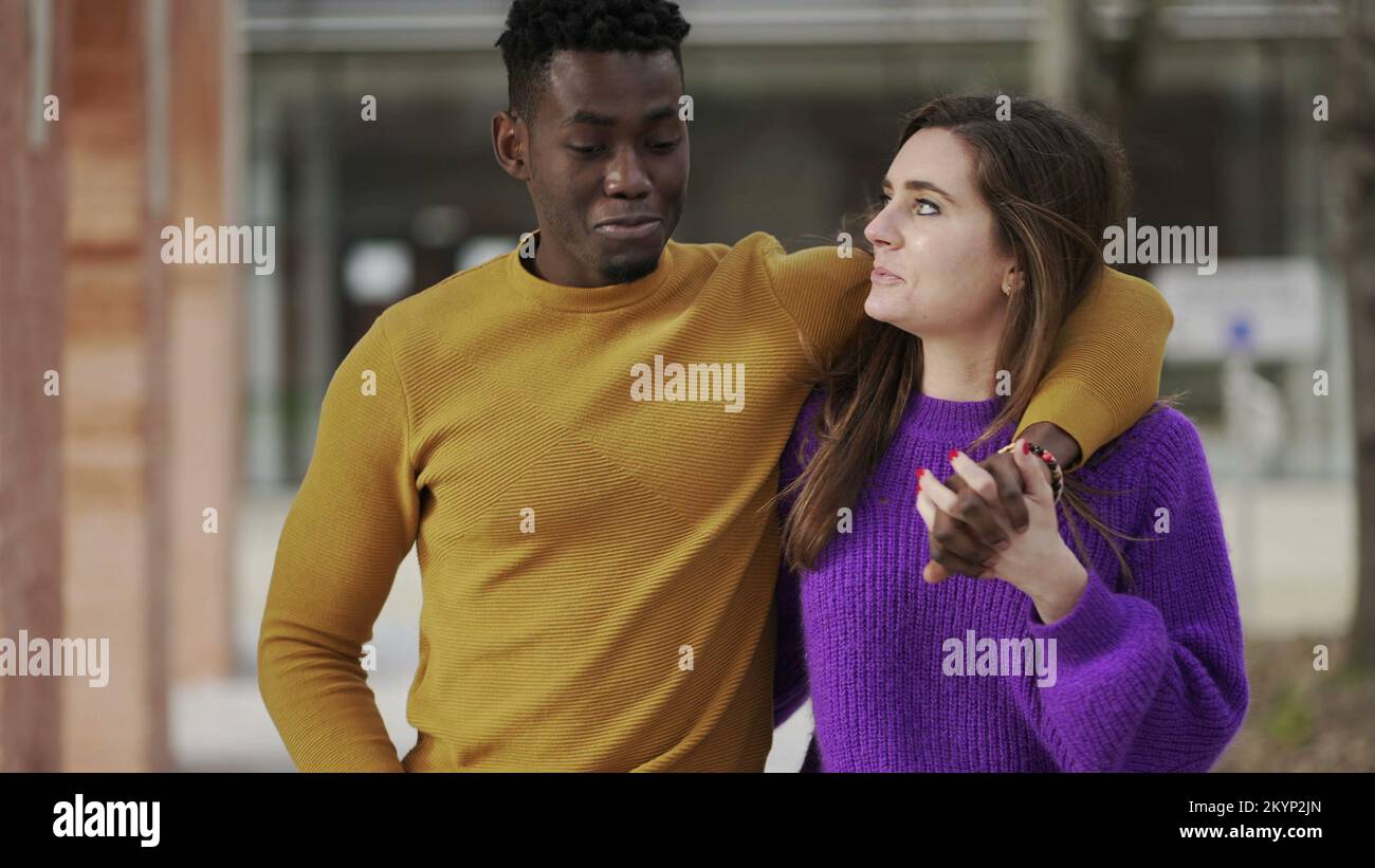 Young interracial couple walking together showing love and affection ...