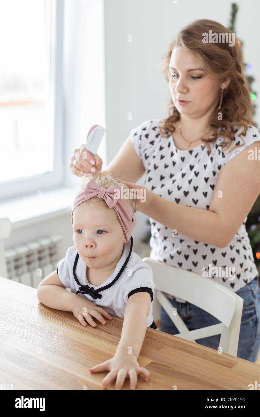 Mother fixing her daughter's cochlear implant hearing aid - diversity ...