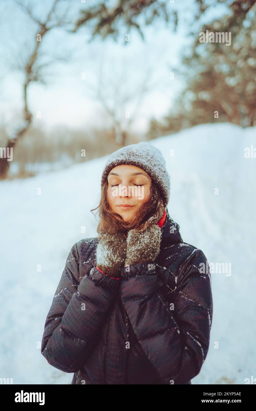 Young woman enjoying winter weather in the snow forest. Cold weather ...