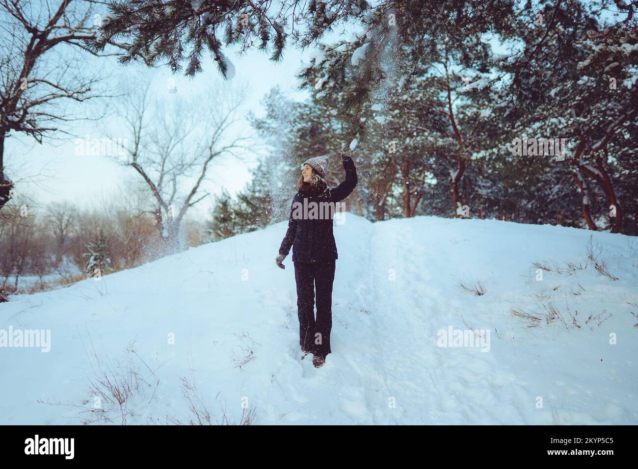 Young woman enjoying winter weather in the snow forest. Cold weather ...