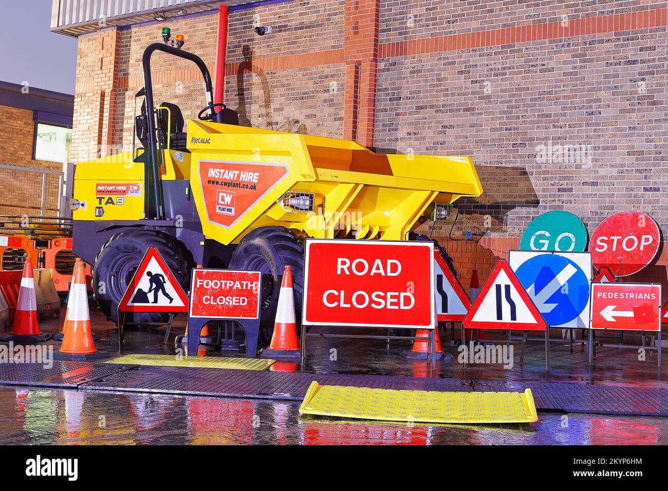 A 9 tonne forward tipping dump truck and road signs at a plant hire ...