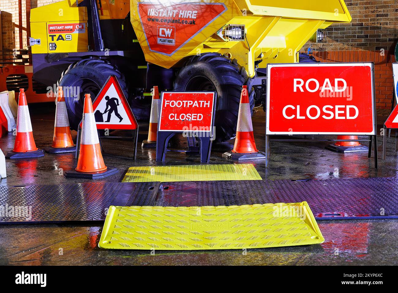 A 9 tonne forward tipping dump truck and road signs at a plant hire ...